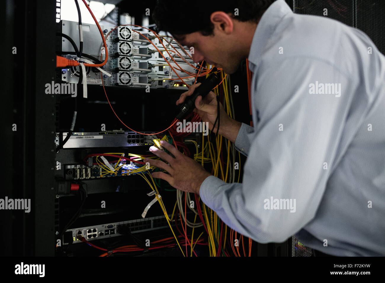Technician looking at open server locker Stock Photo - Alamy