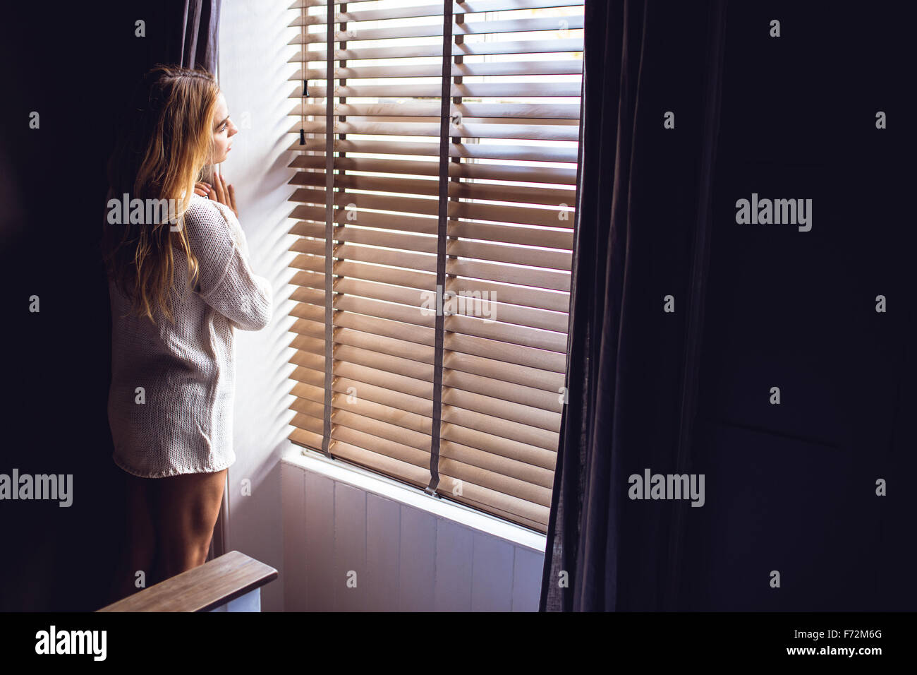 Pretty woman looking at the window Stock Photo - Alamy