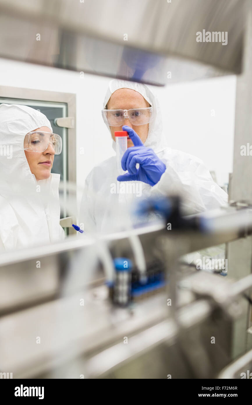 Scientists looking at beaker together Stock Photo - Alamy