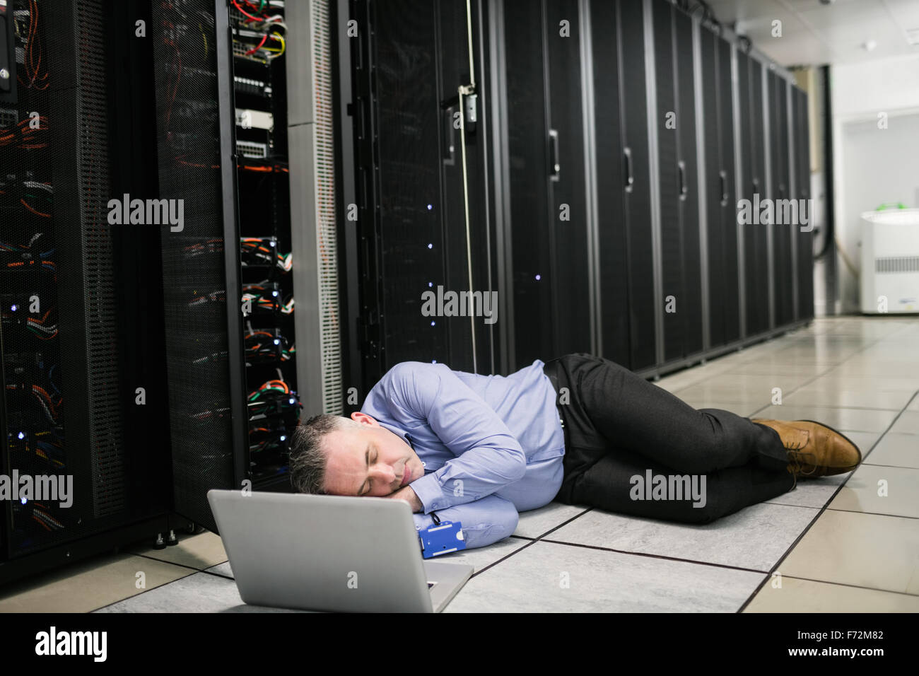 Technician napping in server room Stock Photo - Alamy