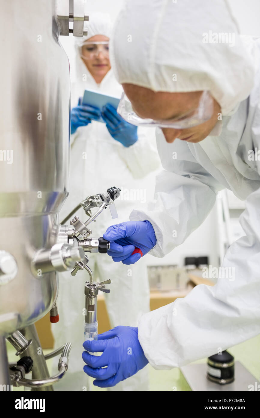 Scientists working with large vat Stock Photo - Alamy