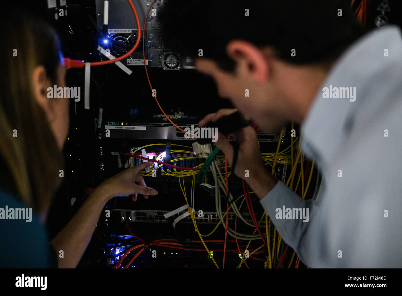 Technician looking at open server locker Stock Photo - Alamy