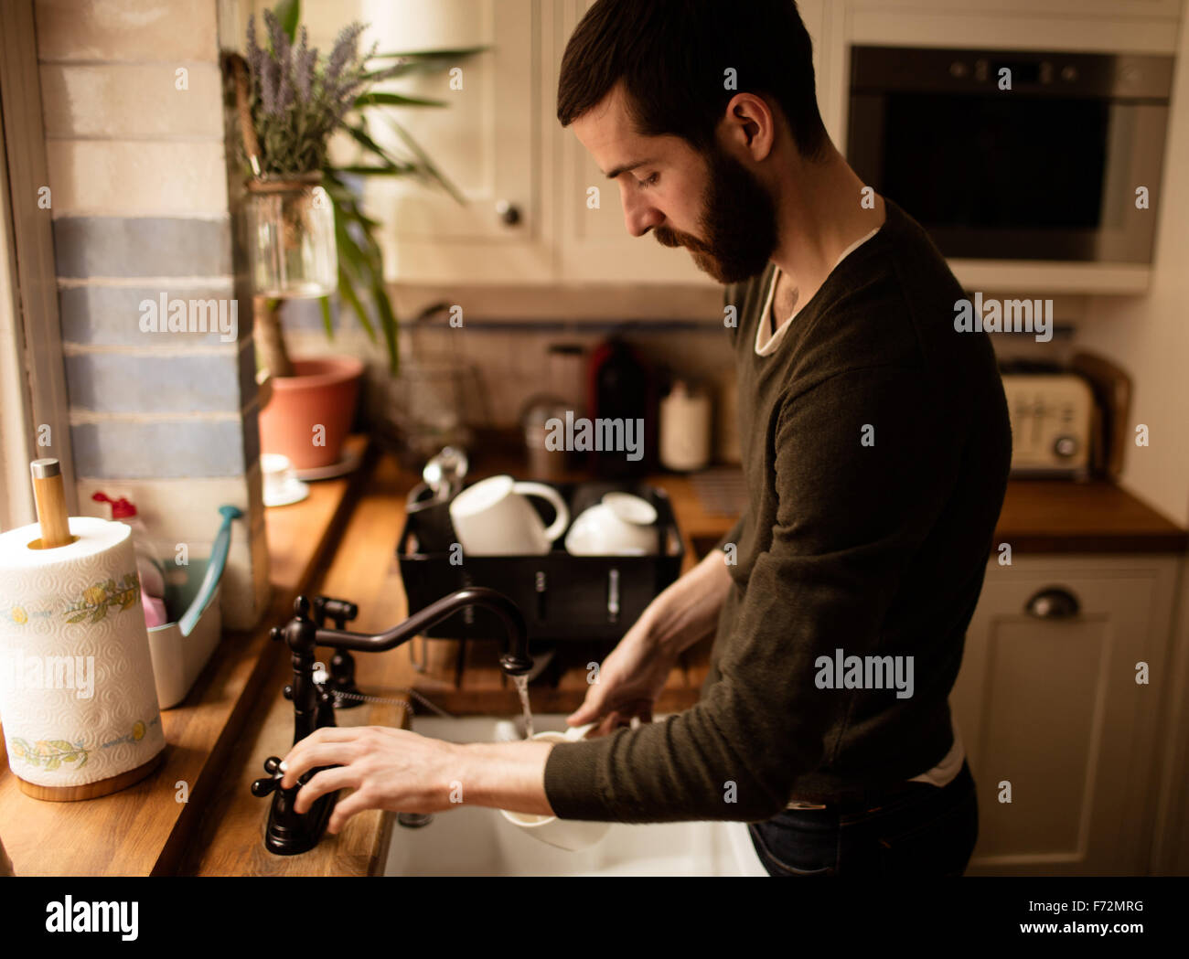 Man washing his cup in kitchen Stock Photo - Alamy