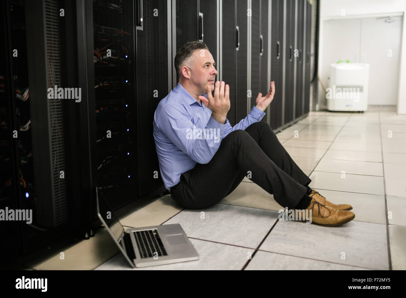 Technician feeling the pressure in server room Stock Photo - Alamy