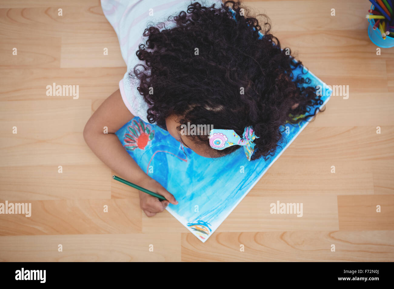 Cute girl laying on the floor drawing Stock Photo - Alamy