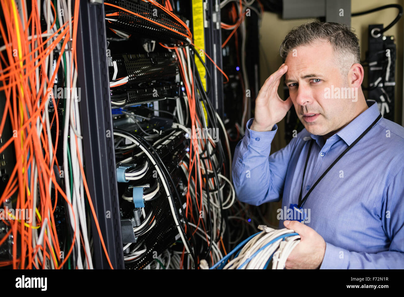 Stressed technician looking at open server locker Stock Photo - Alamy