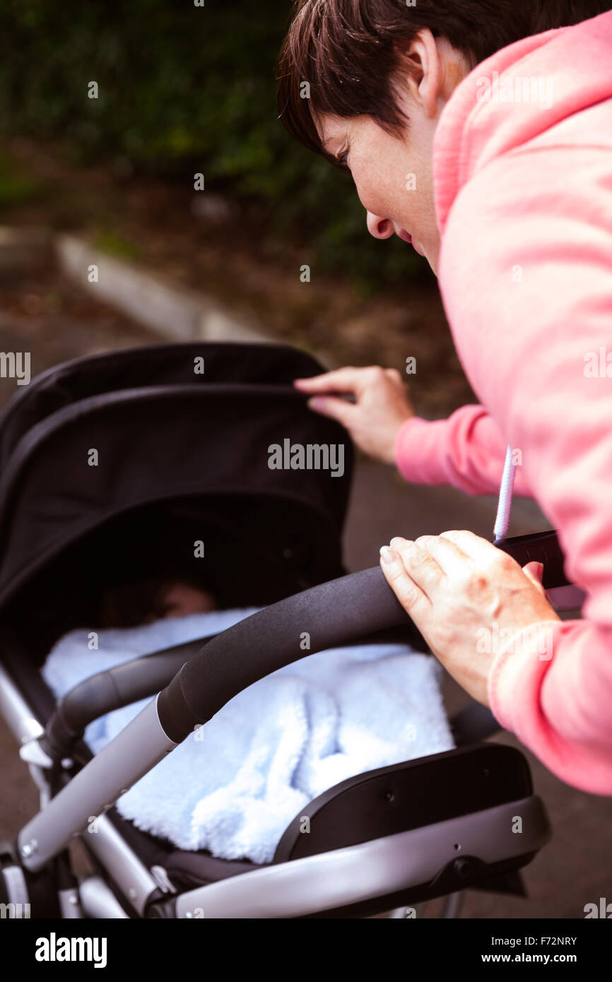 Mother walking and pushing pram Stock Photo - Alamy