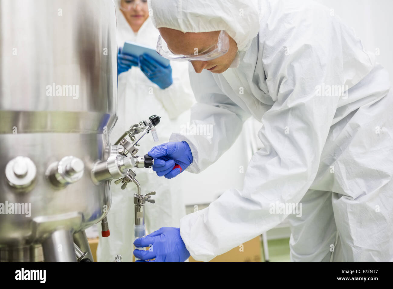 Scientists working with large vat Stock Photo - Alamy