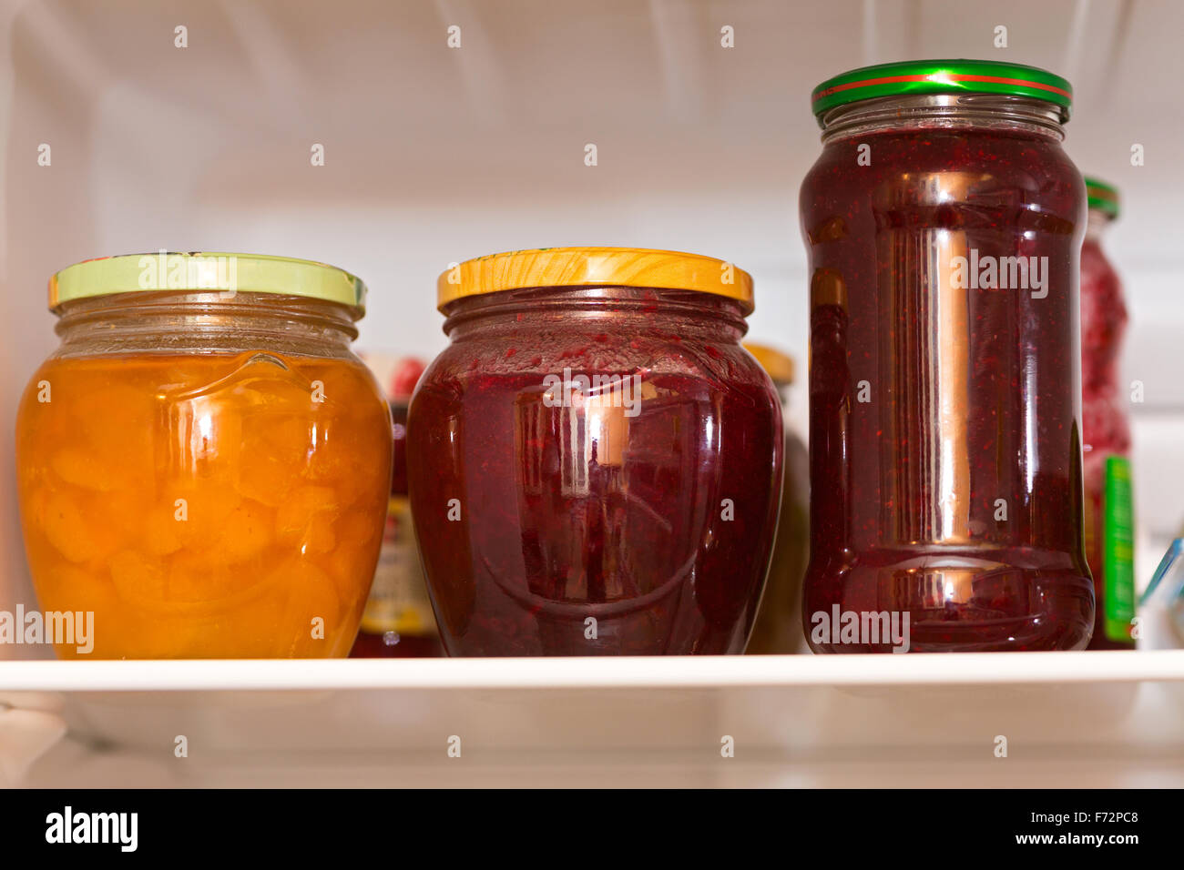 Jam in glass jars standing on a shelf of the refrigerator Stock Photo ...