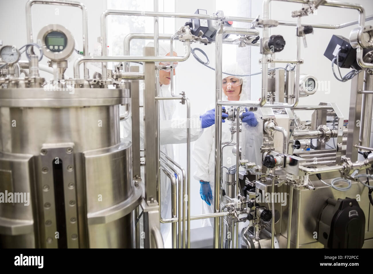 Scientists working with large vat Stock Photo - Alamy