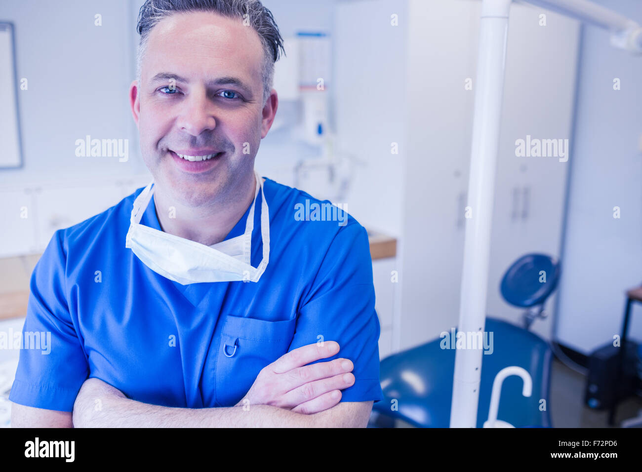 Smiling male dentist with arms crossed Stock Photo - Alamy