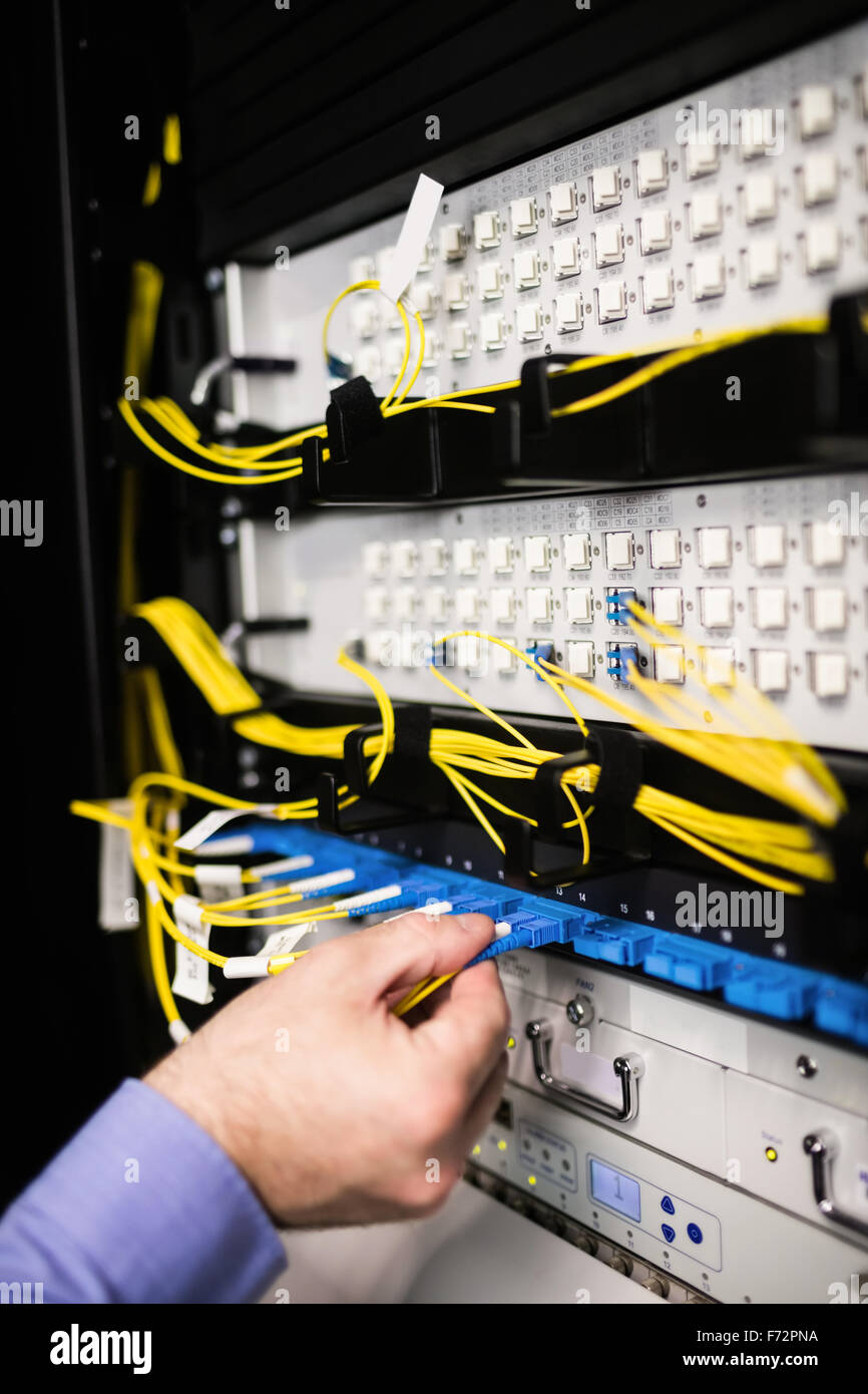 Technician inserting wire to server Stock Photo - Alamy