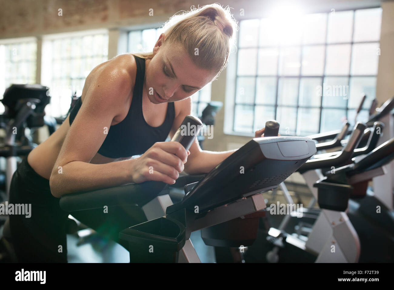 Fitness woman on bicycle doing cardio workout at gym. Fit young female ...