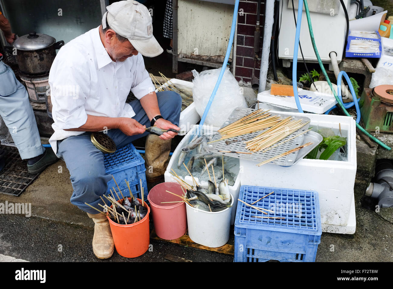 A man in Japan prepares "ayu" fish (in English known as sweetfish) for ...
