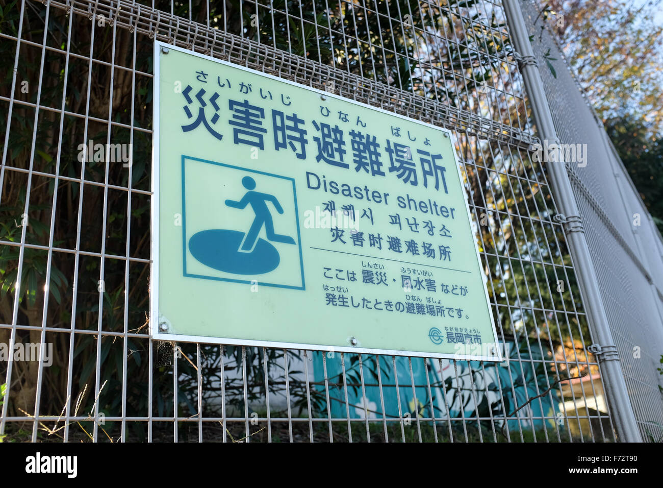 A sign indicating the location of a disaster shelter in Japan Stock ...