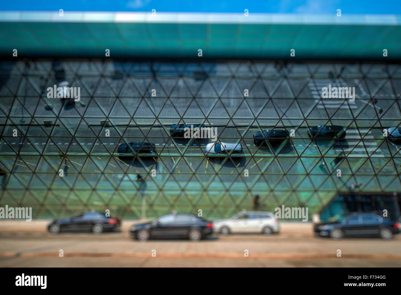 Modern airport terminal facade with cars and people's reflections Stock ...
