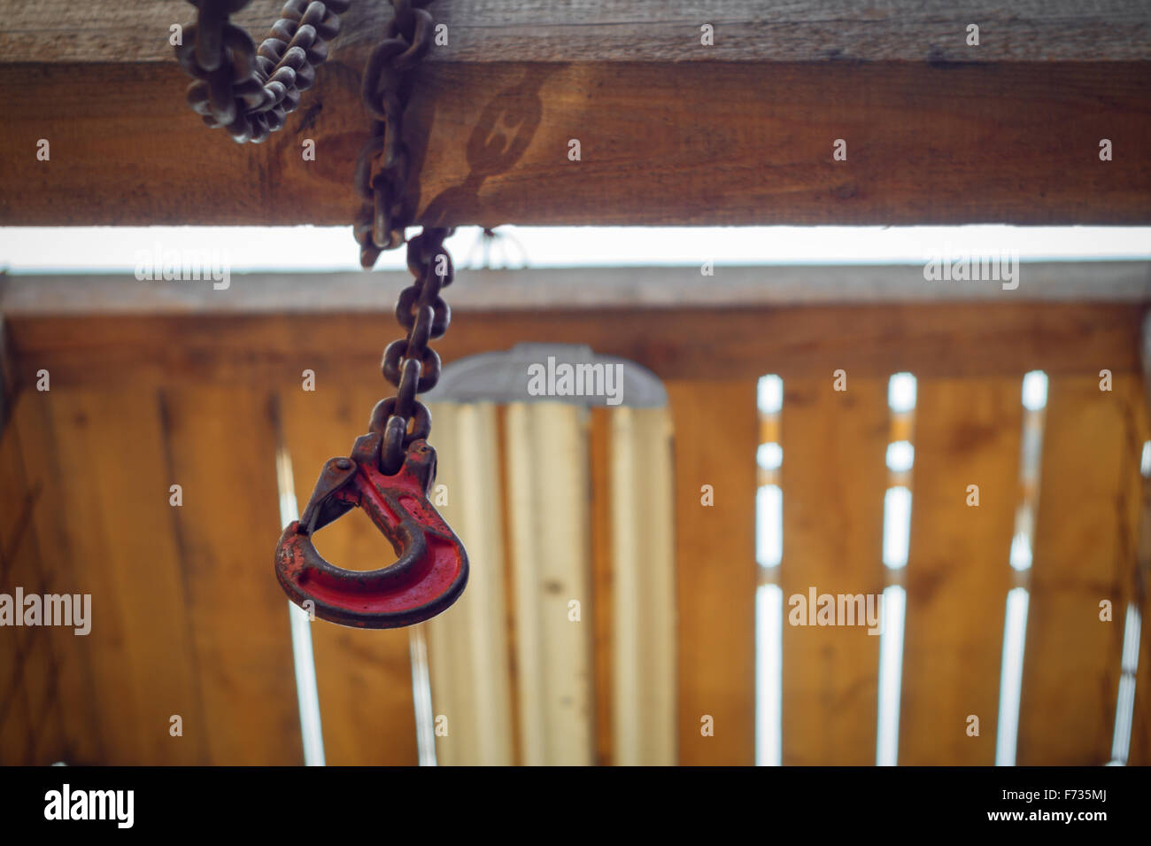 Hook with a chain is attached to the wooden beam Stock Photo - Alamy