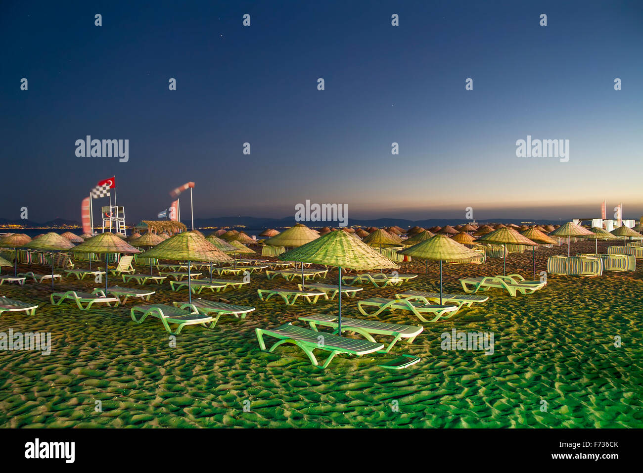 Beds and straw umbrellas on Sarimsakli Beach, Turkey At Night Stock ...