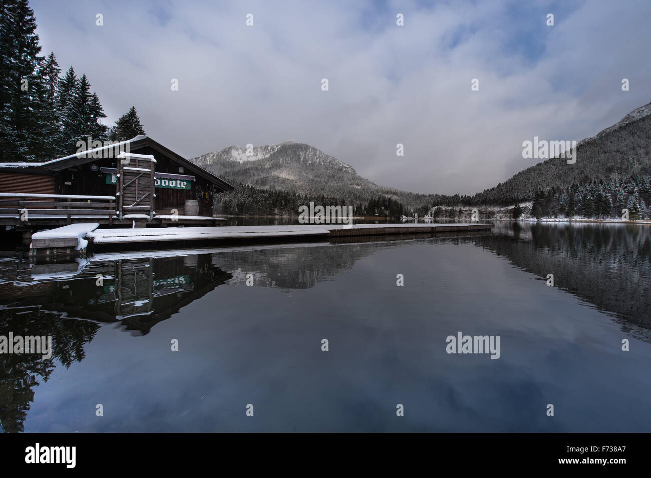 Snow-covered mountains mirror on the calm water surface of lake ...