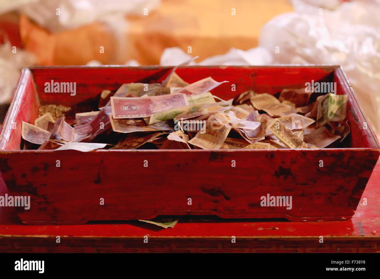 Red painted wooden box-money offerings-small value banknotes. Shrine on ...