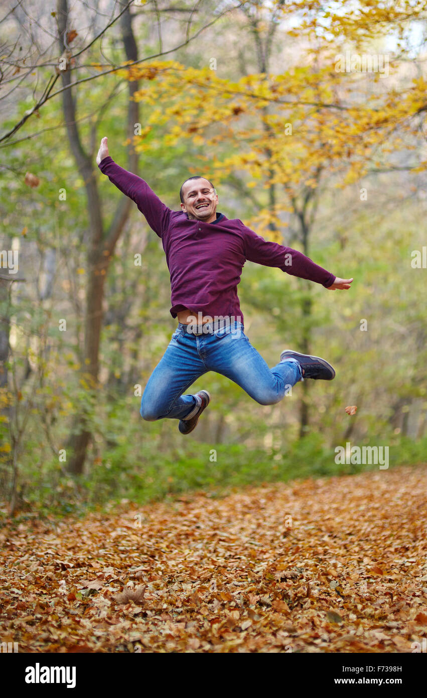 Happy caucasian man jumping for joy in the forest Stock Photo - Alamy