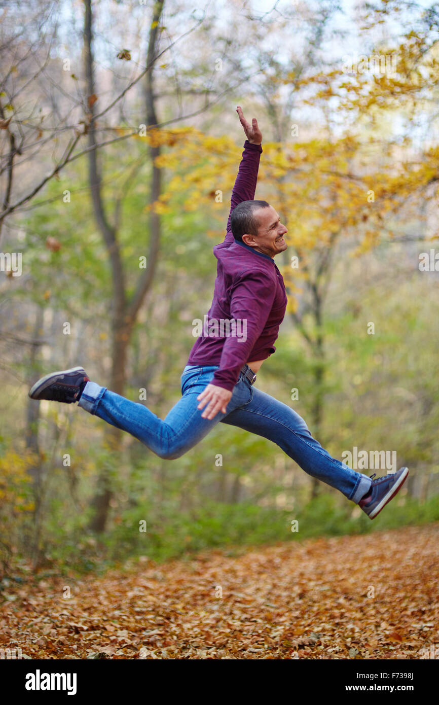 Happy caucasian man jumping for joy in the forest Stock Photo - Alamy