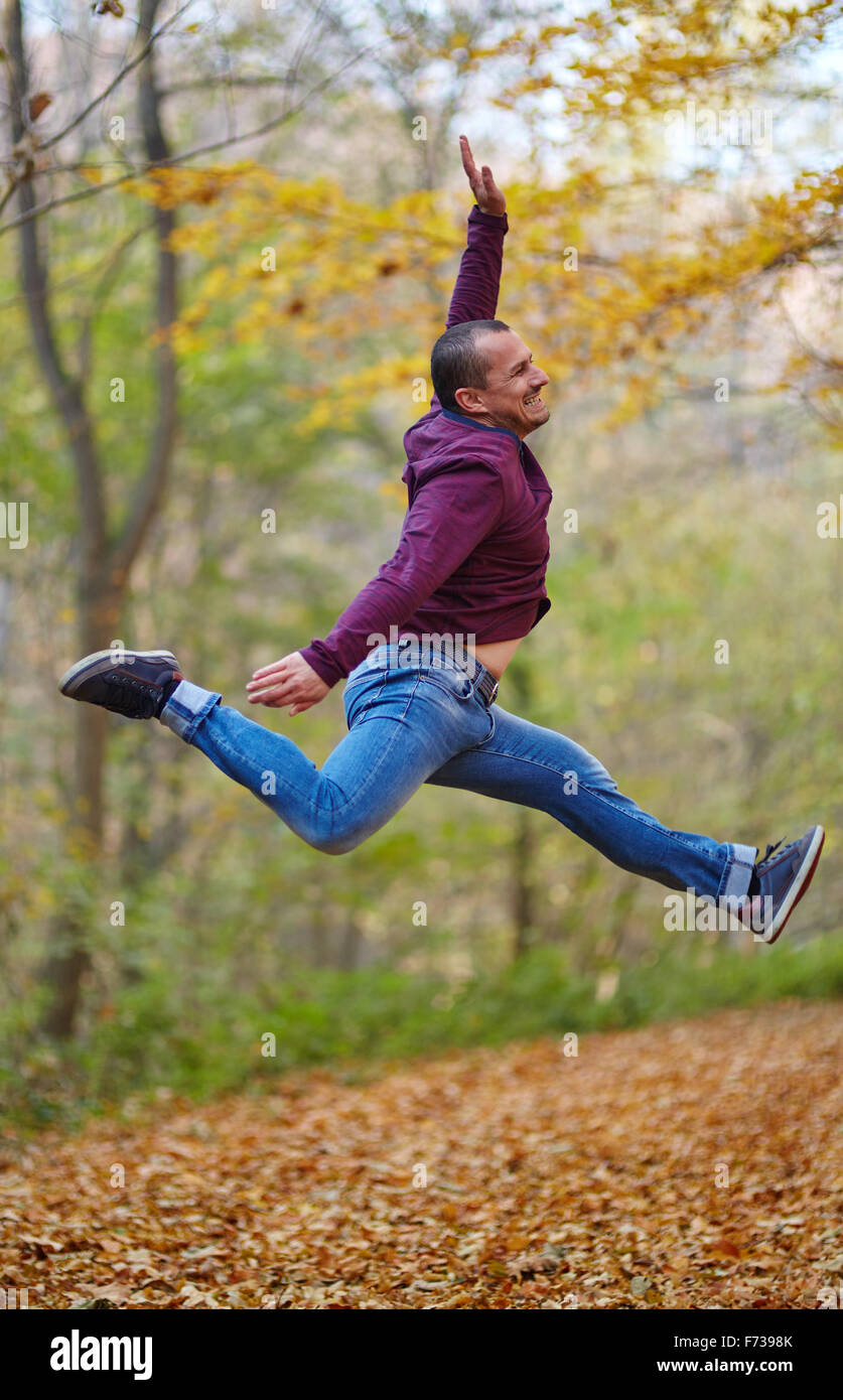 Happy caucasian man jumping for joy in the forest Stock Photo - Alamy