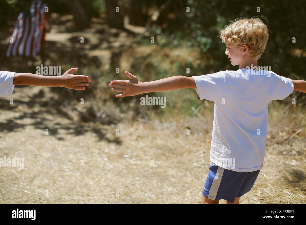 Boys play with their both hands fully stretched to their side and ...