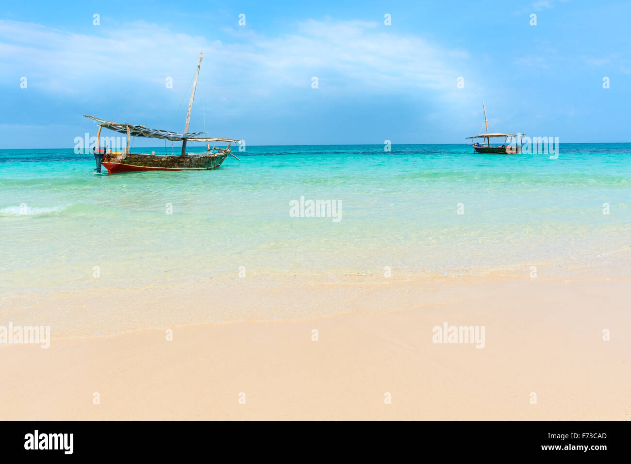 Anchored wooden dhow boats on the amazing turquoise water in the Indian ...