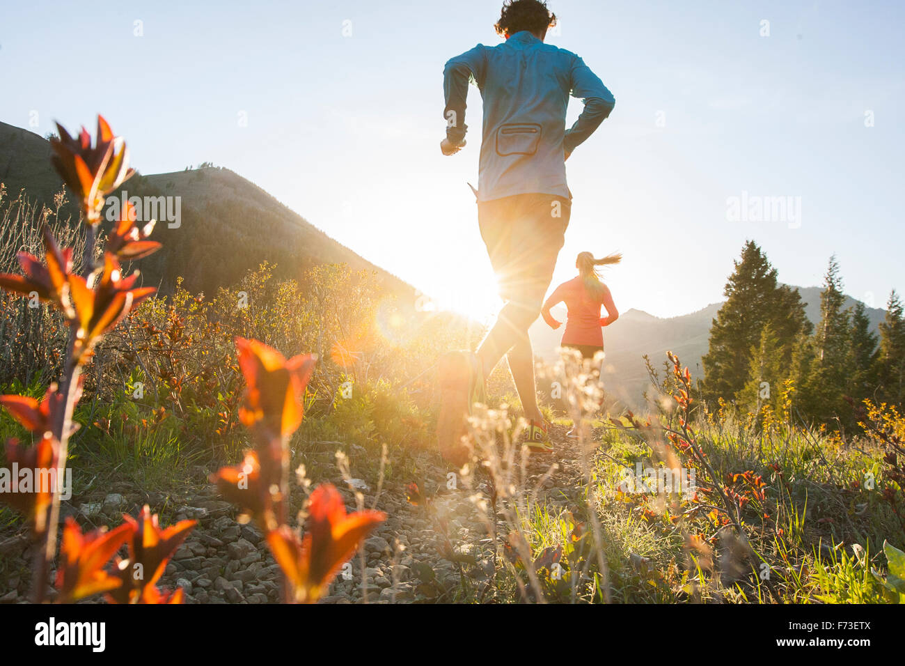 A couple trail running at sunset Stock Photo - Alamy