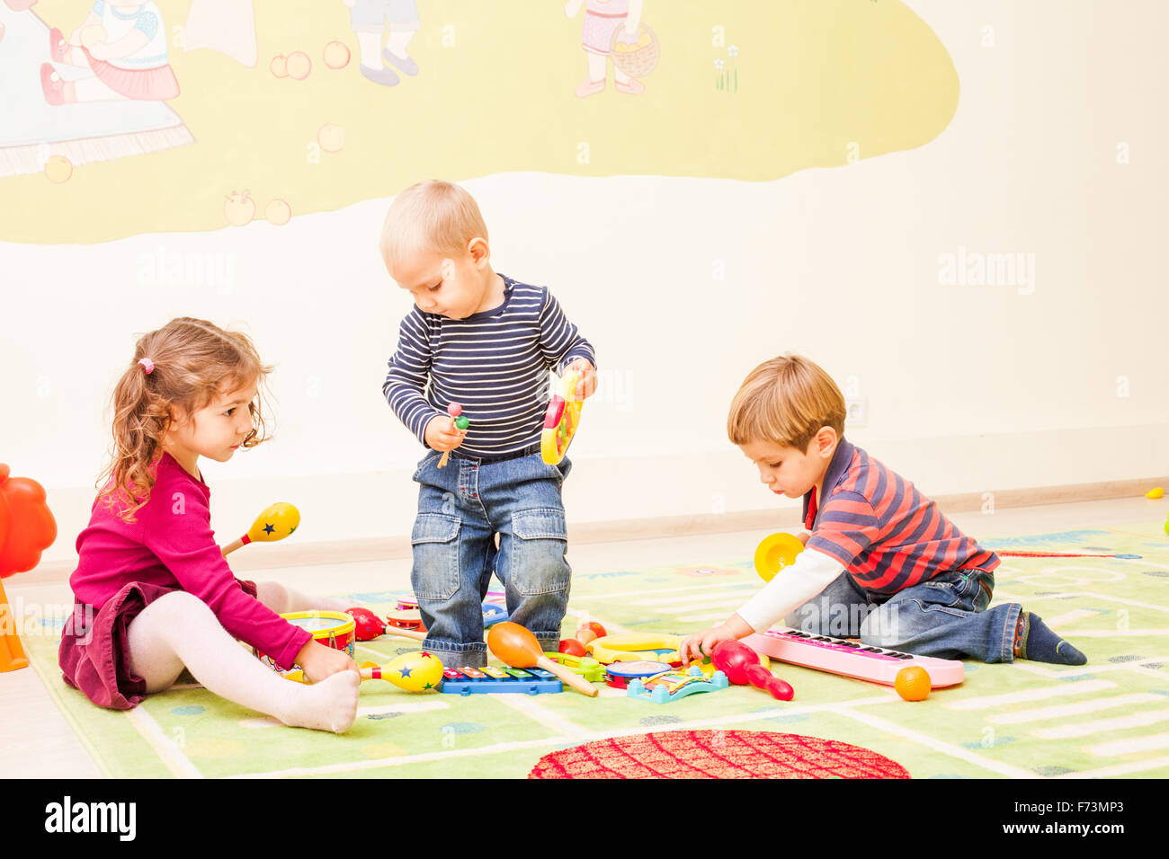 Three kids playing with toys Stock Photo - Alamy