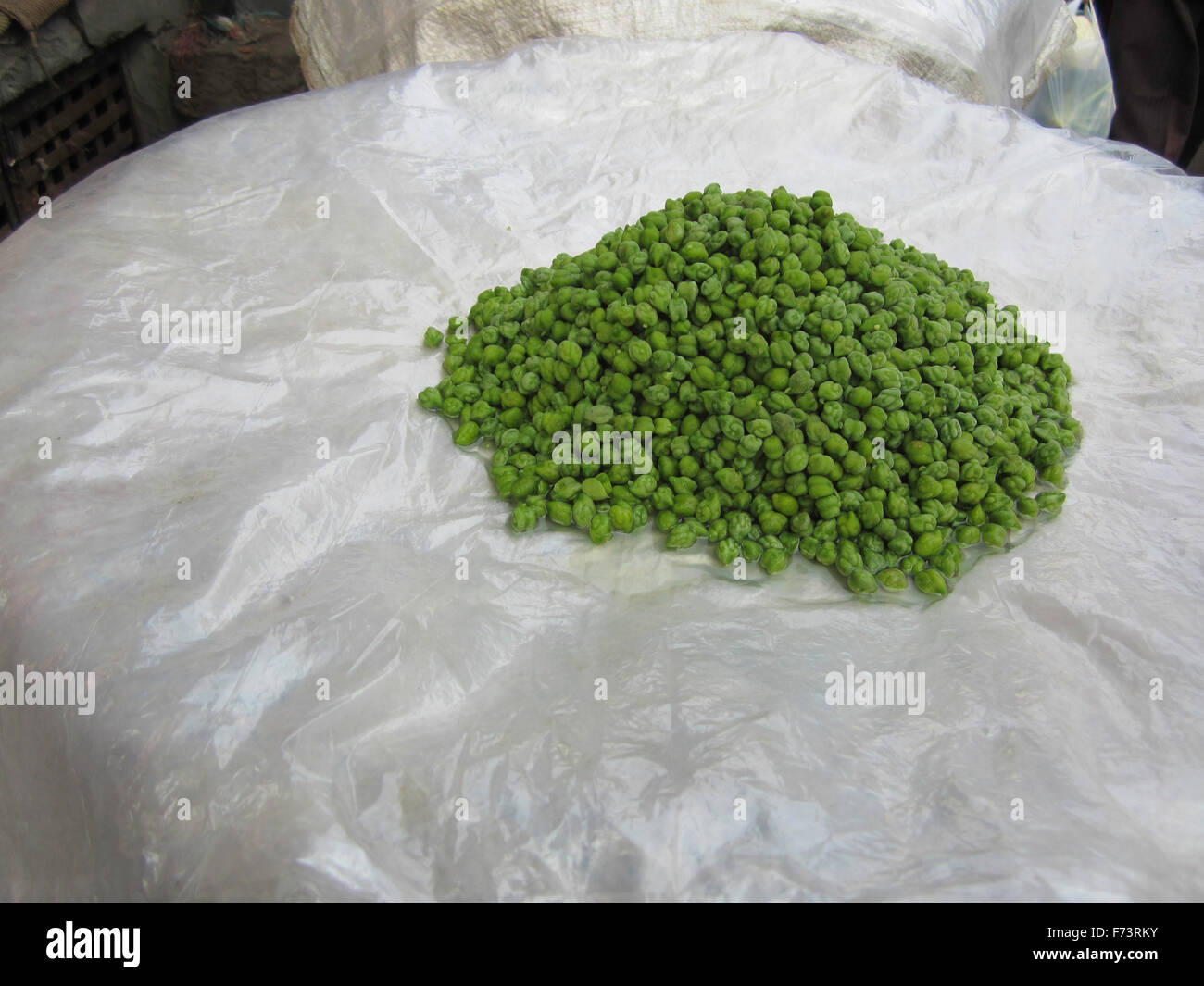 Circle of green peas on plastic sheeting on display at food market ...