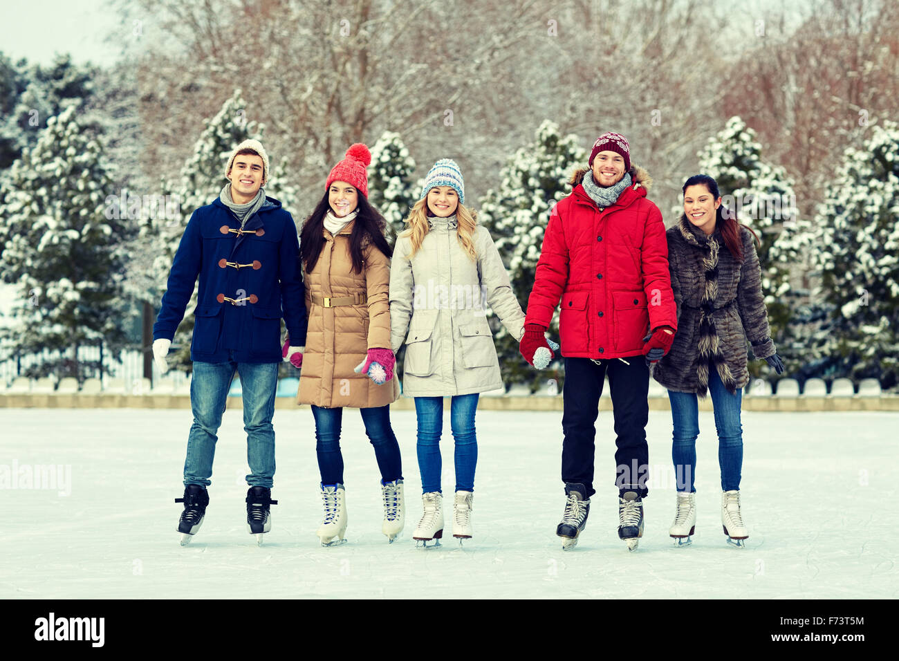 happy friends ice skating on rink outdoors Stock Photo - Alamy