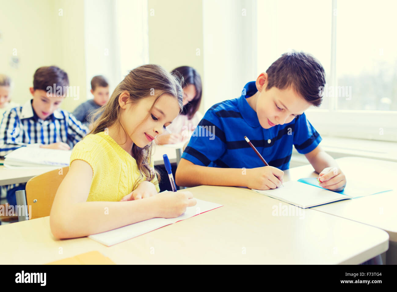 group of school kids writing test in classroom Stock Photo - Alamy