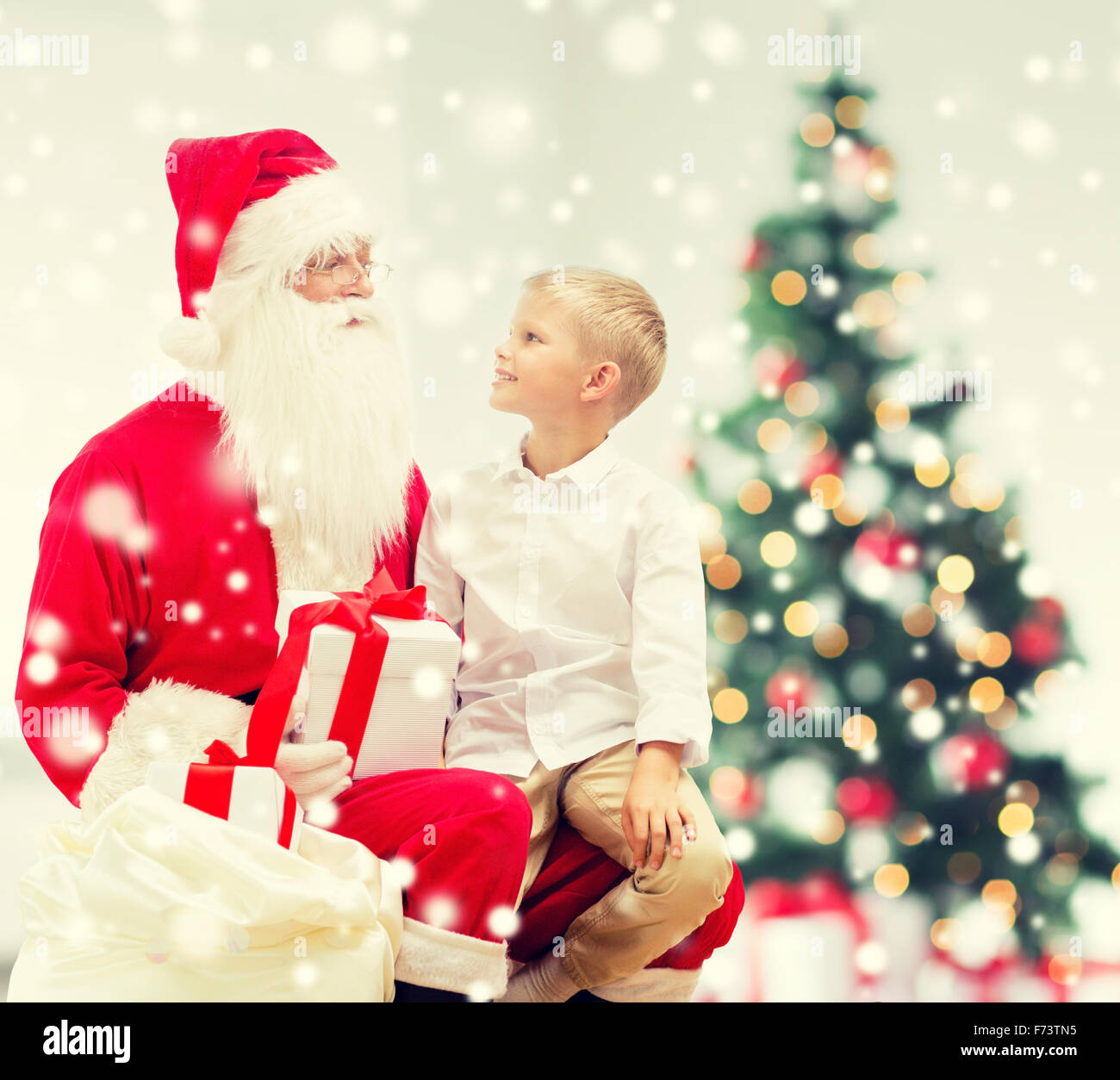 smiling little boy with santa claus and gifts Stock Photo - Alamy