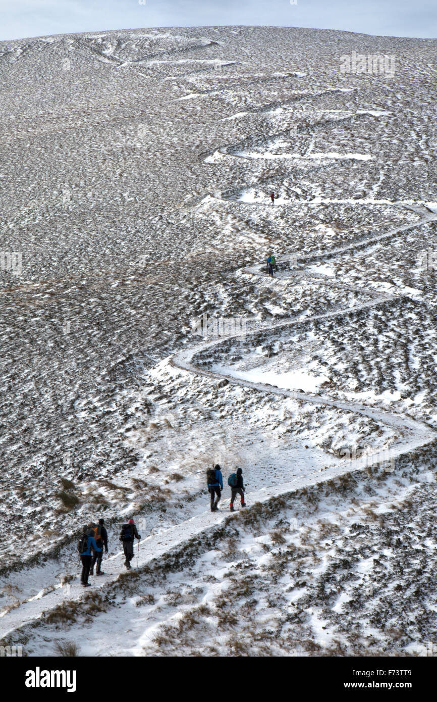 Hikers ascending a winding, zig zag path, up a small mountain in the ...