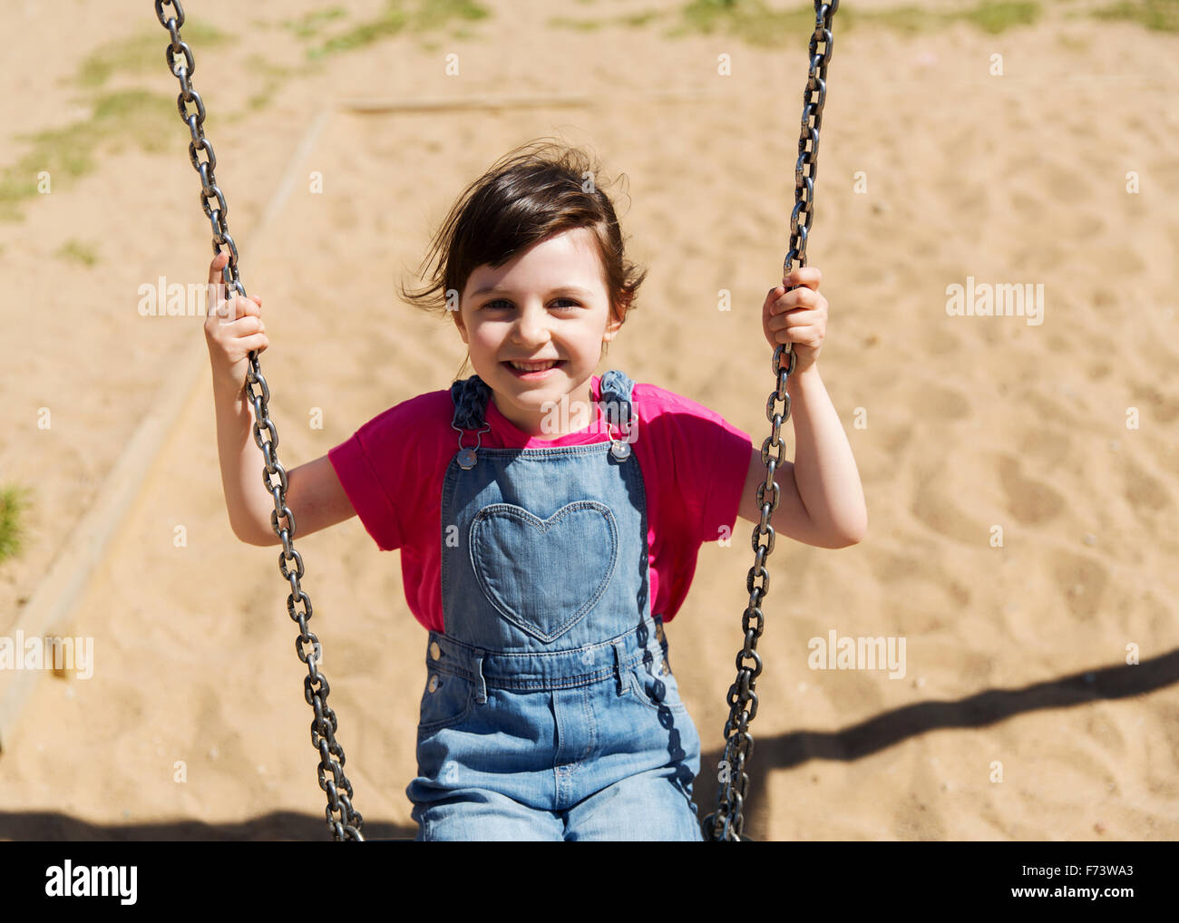Happy girl swinging on playground hi-res stock photography and images ...