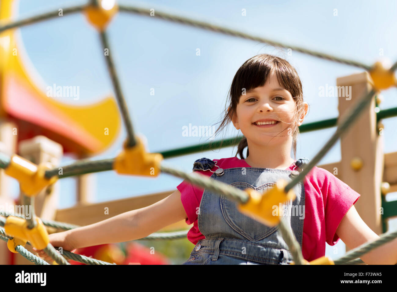 happy little girl climbing on children playground Stock Photo - Alamy