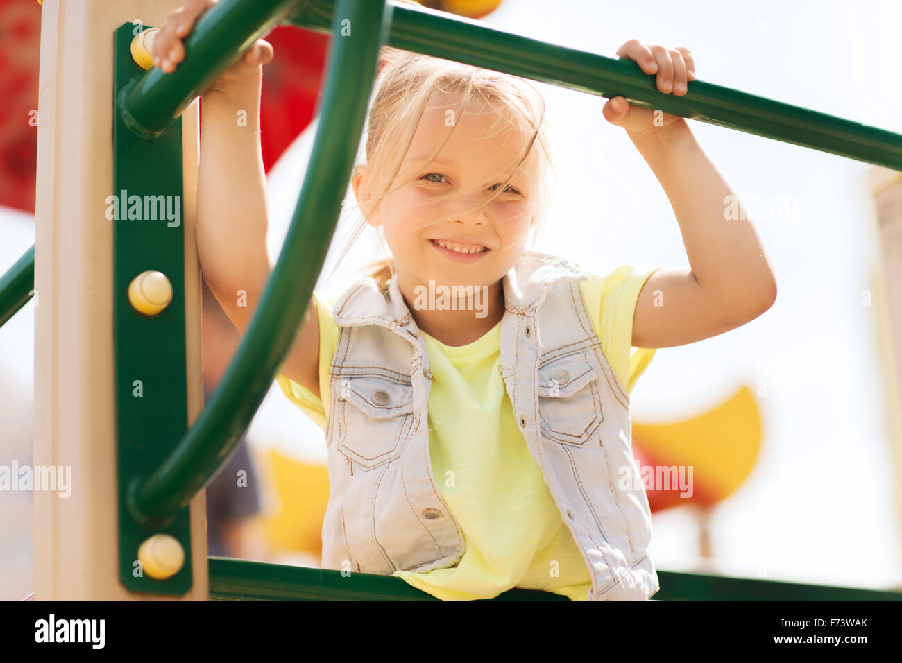 happy little girl climbing on children playground Stock Photo - Alamy