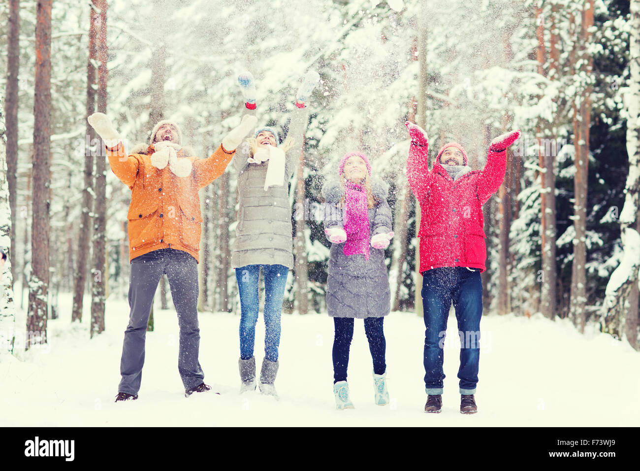 group of happy friends playin with snow in forest Stock Photo - Alamy