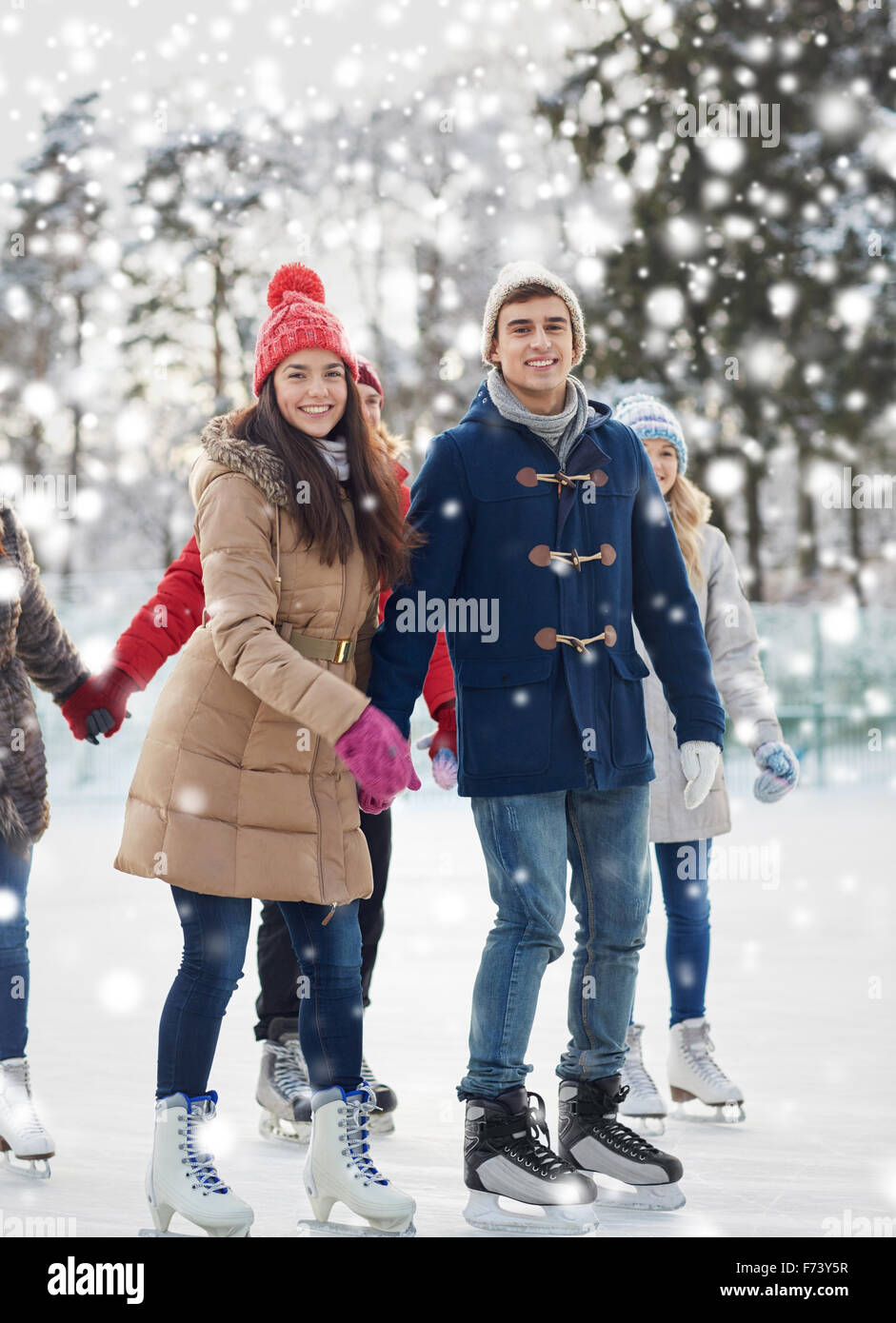 happy friends ice skating on rink outdoors Stock Photo - Alamy