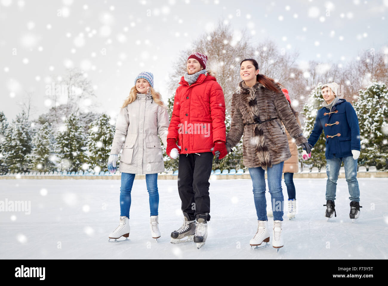 happy friends ice skating on rink outdoors Stock Photo - Alamy