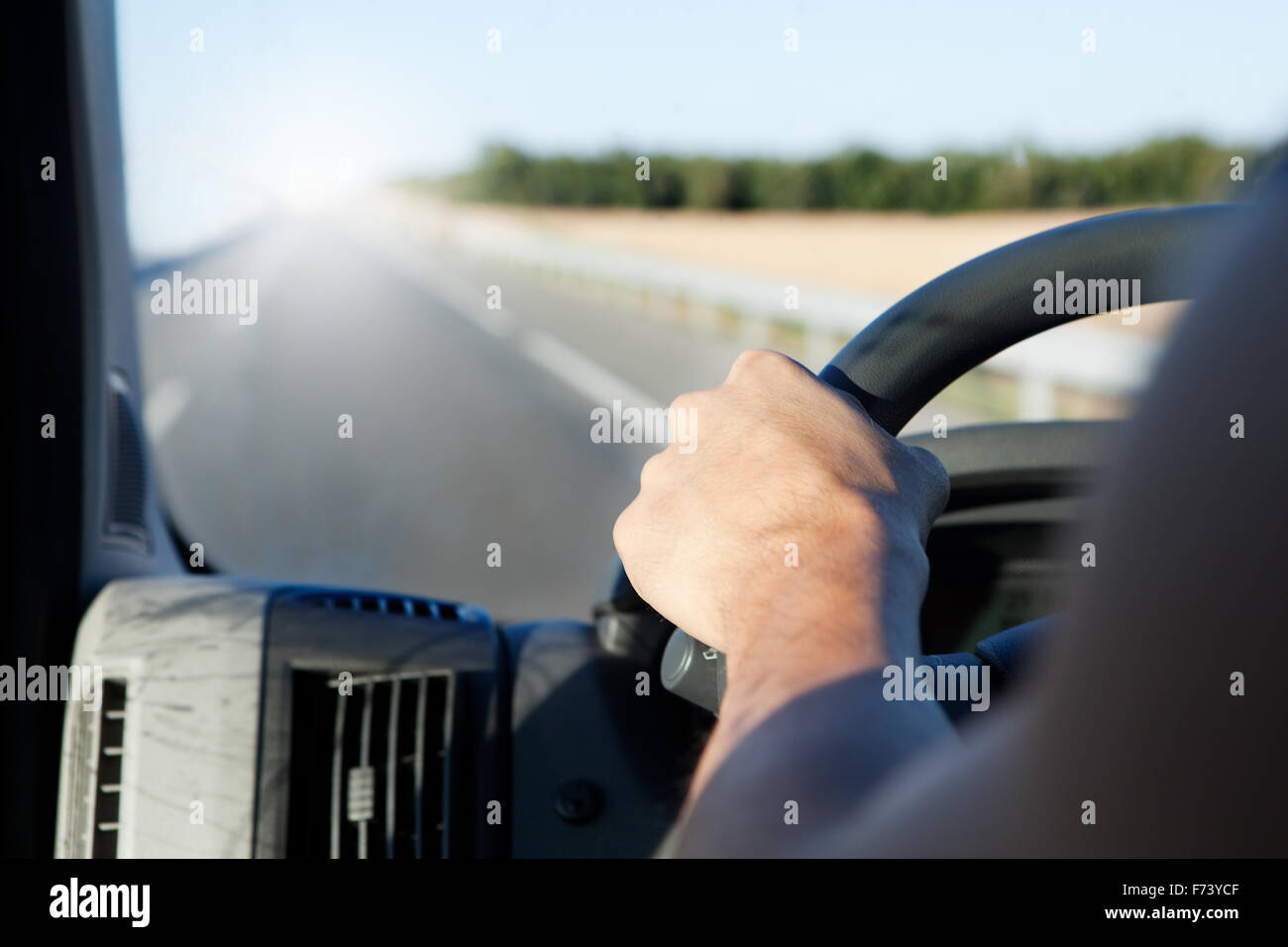 Detail of driver's hand and road Stock Photo - Alamy