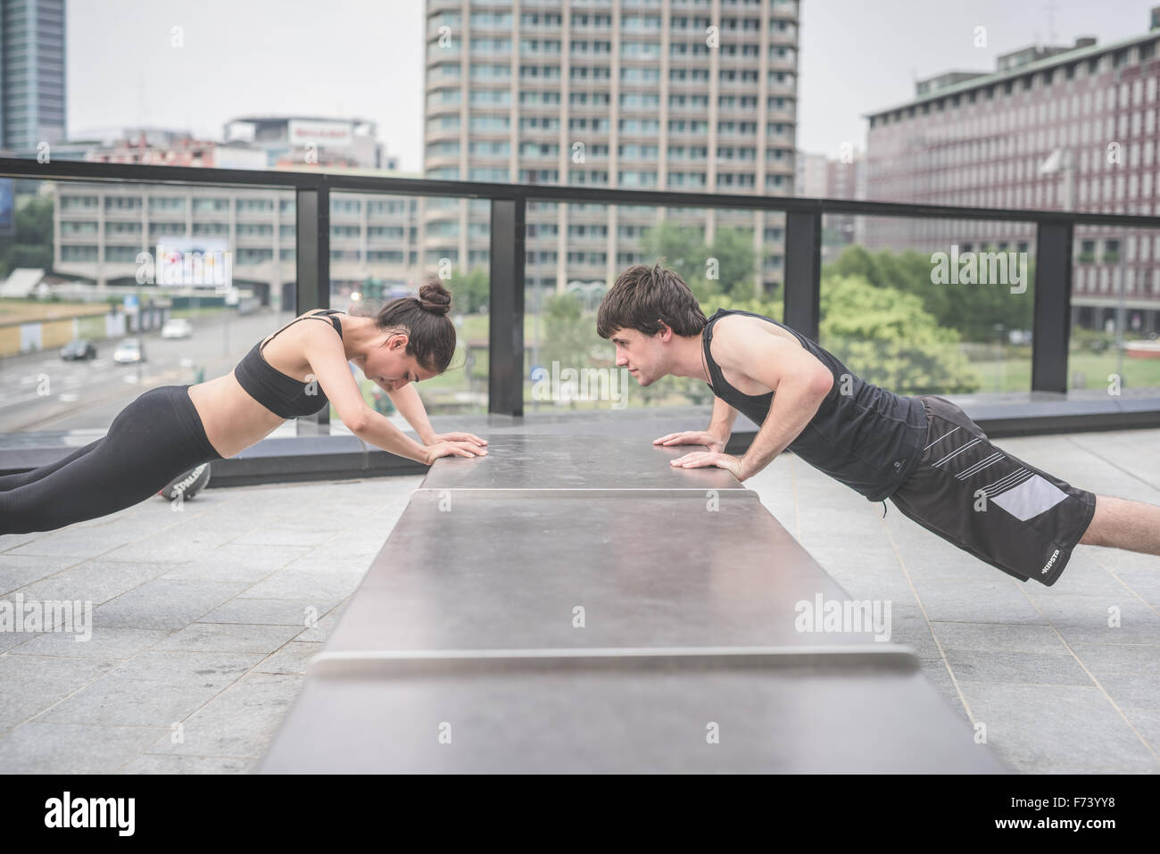 Couple of young handsome caucasian sportive man and woman doing push ...