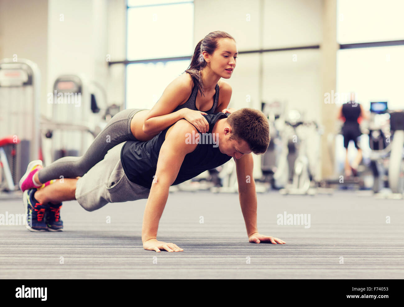 smiling couple doing push-ups in the gym Stock Photo - Alamy