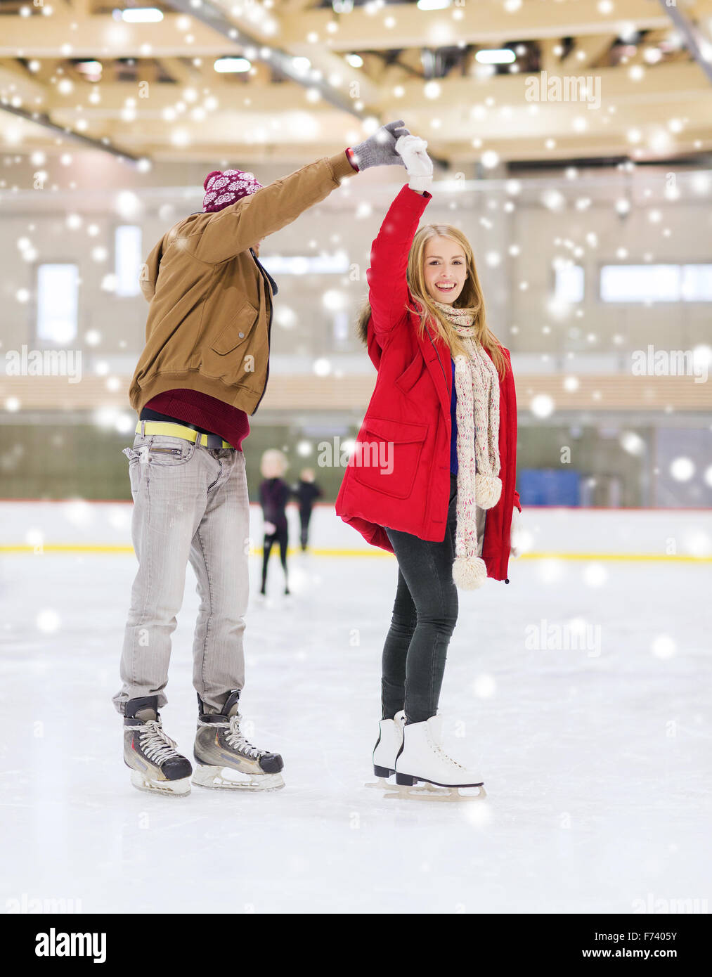 happy couple holding hands on skating rink Stock Photo - Alamy