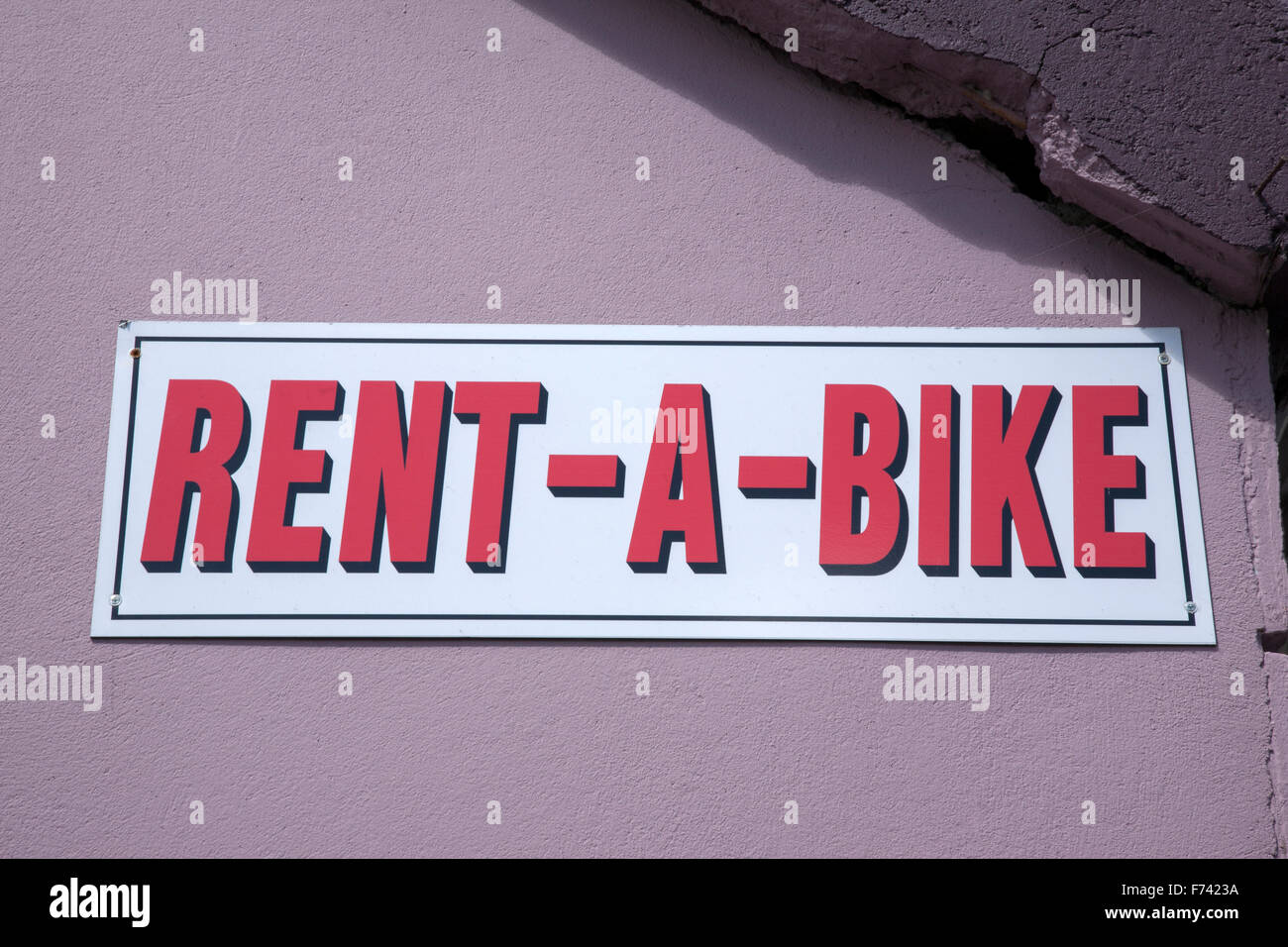 Rent a Bike Sign on Stone Wall Stock Photo - Alamy