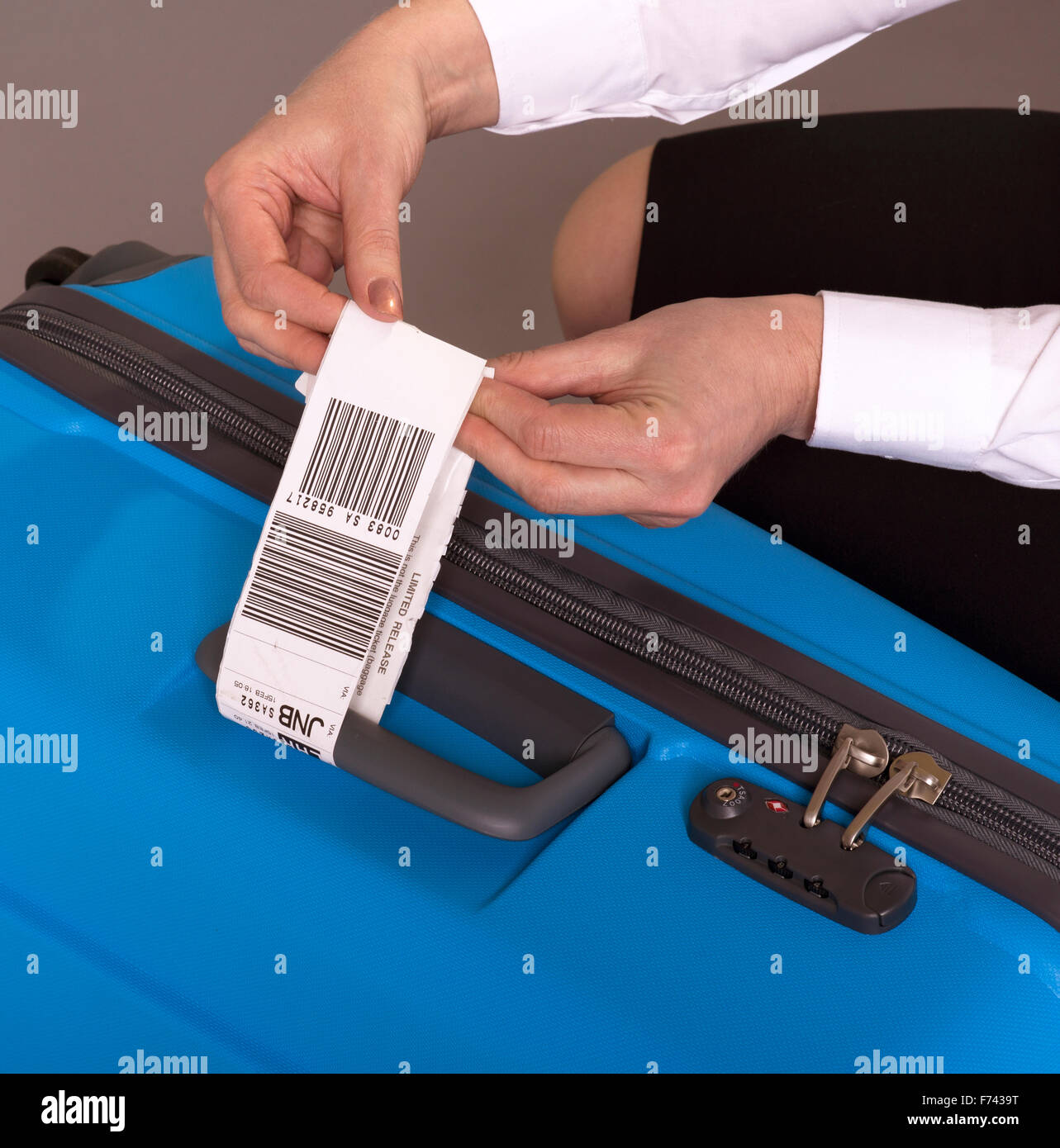 Airline check in luggage tag being attached to a suitcase Stock Photo ... Airline check in luggage tag being attached to a suitcase Stock Photo ...