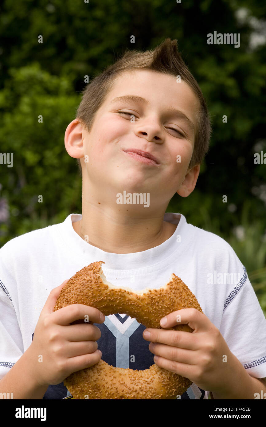 happy boy eating sesame ring Stock Photo - Alamy