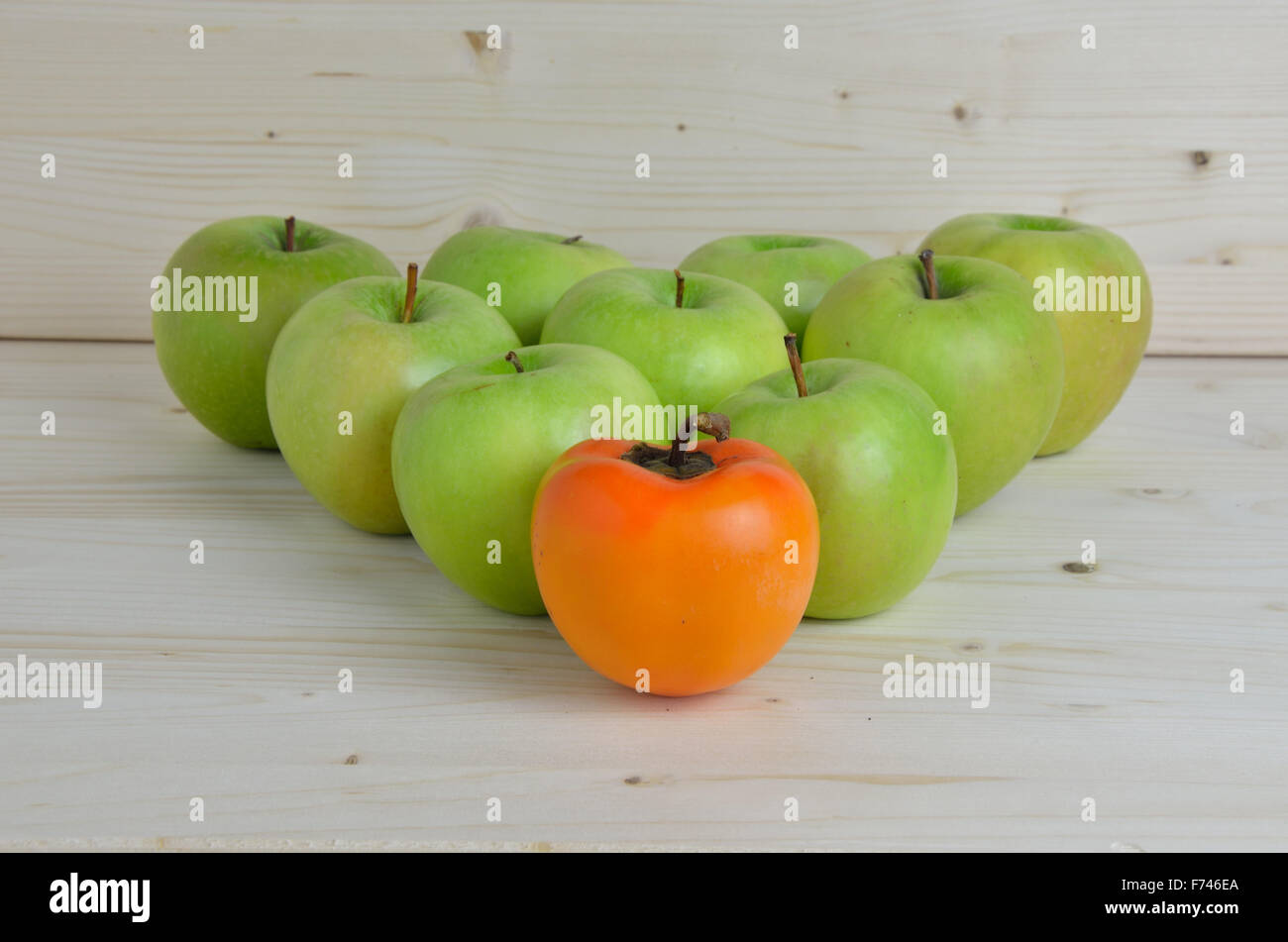 Triangle of green apples with kaki apple in front of others Stock Photo ...